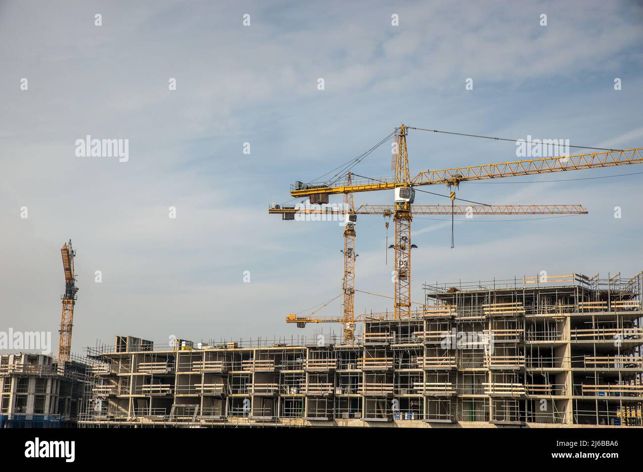 Building site with cranes and scaffolding Stock Photo - Alamy