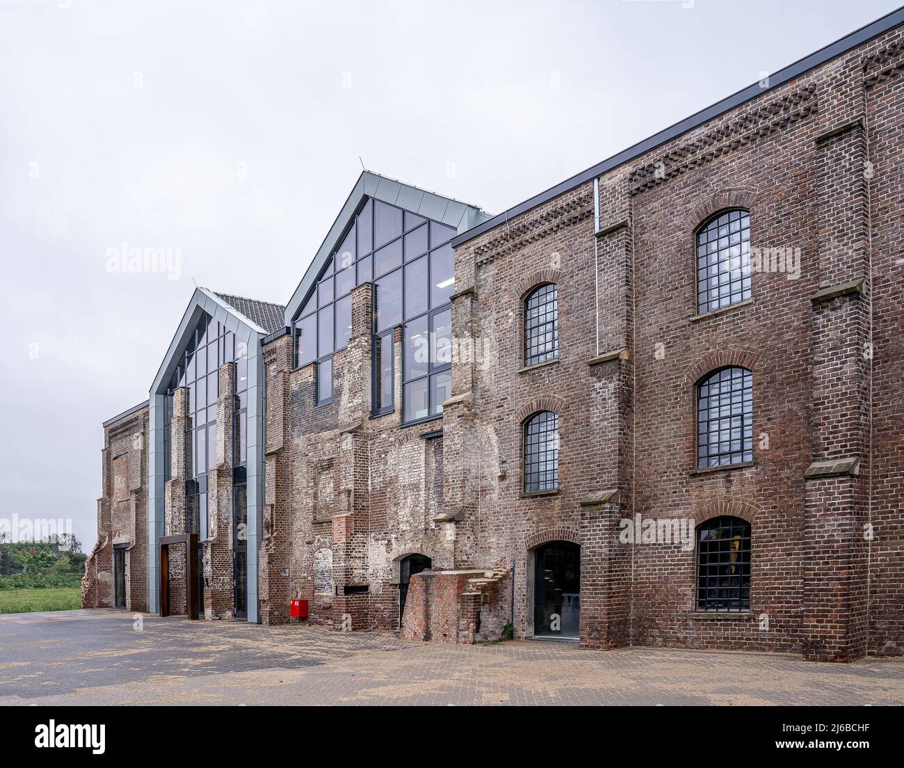 Dark brick facade of an old abandoned factory. The stones are damaged ...