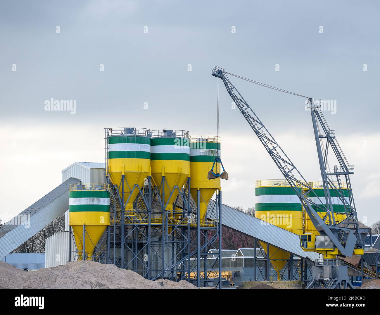 Cement factory with cranes for transporting raw materials. The silos in ...