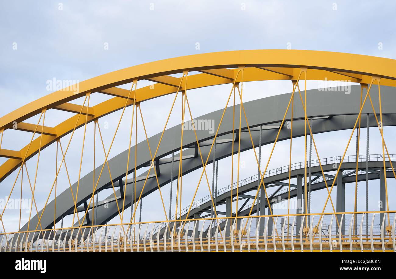 Three steel arch bridges lie side by side and span a river. One of the ...