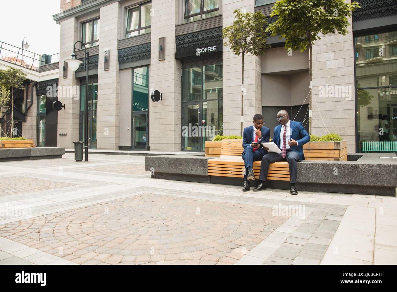 Two dark-skinned african american businessmen in suits with briefcases ...