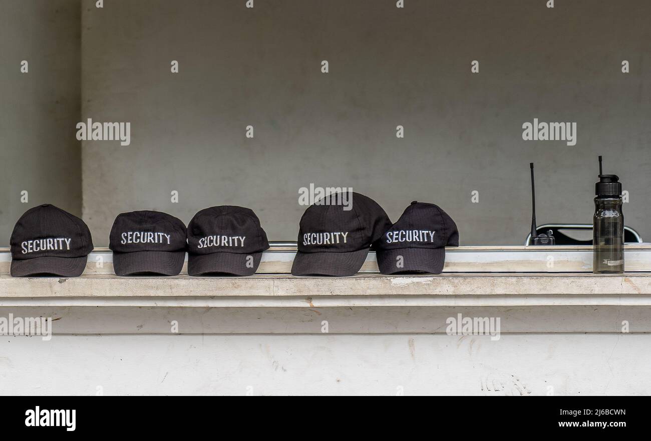 Several caps of security agents are next to each other in a row. The ...