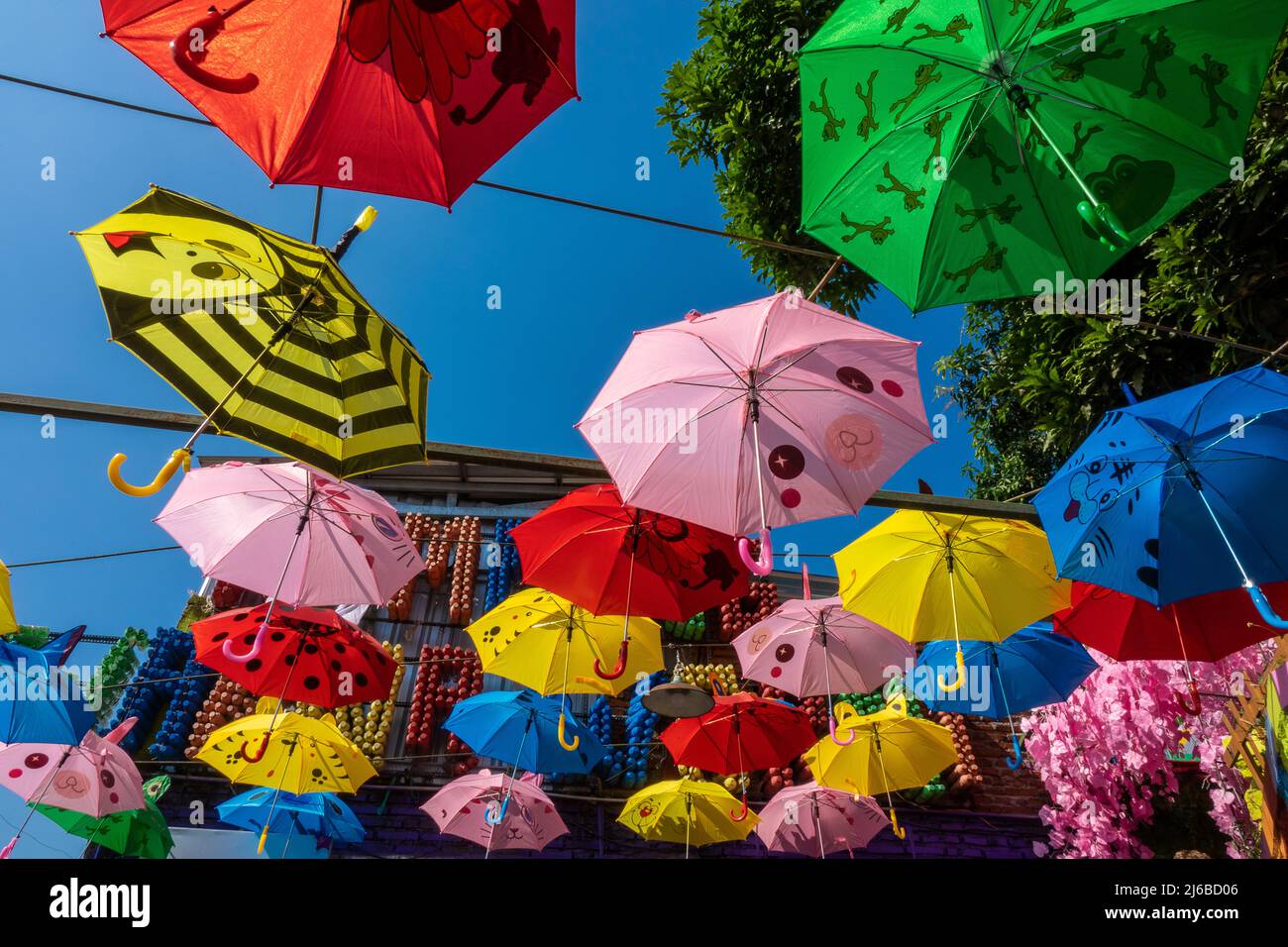 brightly colored umbrellas hanging in the sky in a neighborhood of ...