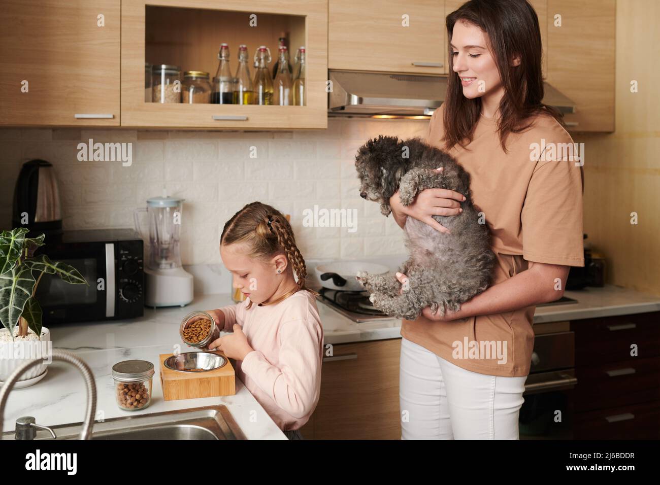 Girl feeding dog bowl hi-res stock photography and images - Alamy