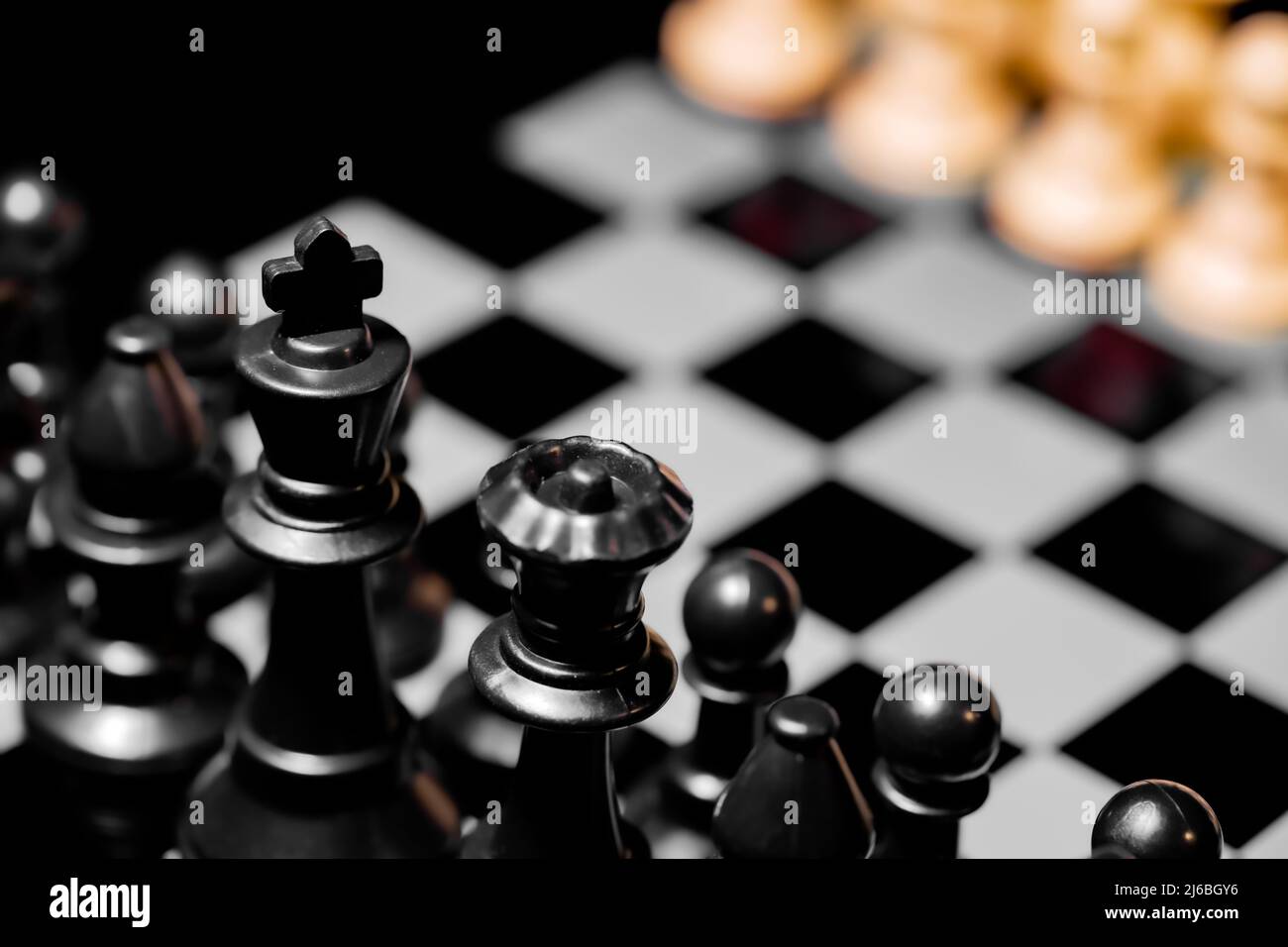Close up of Chess pieces on a reflective mirror board surface with a ...
