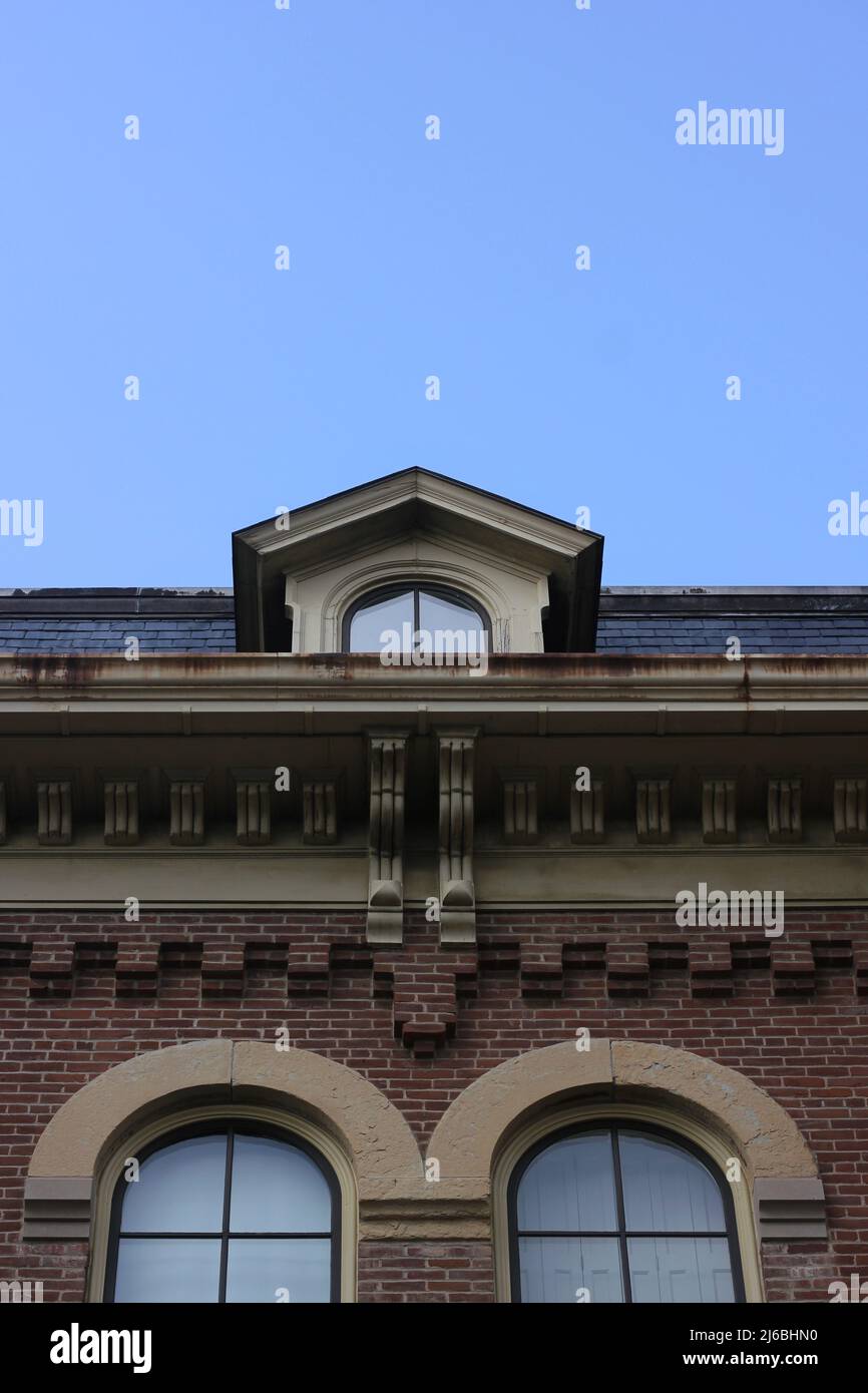 A traditional colonial attic window high on the roofline Stock Photo ...