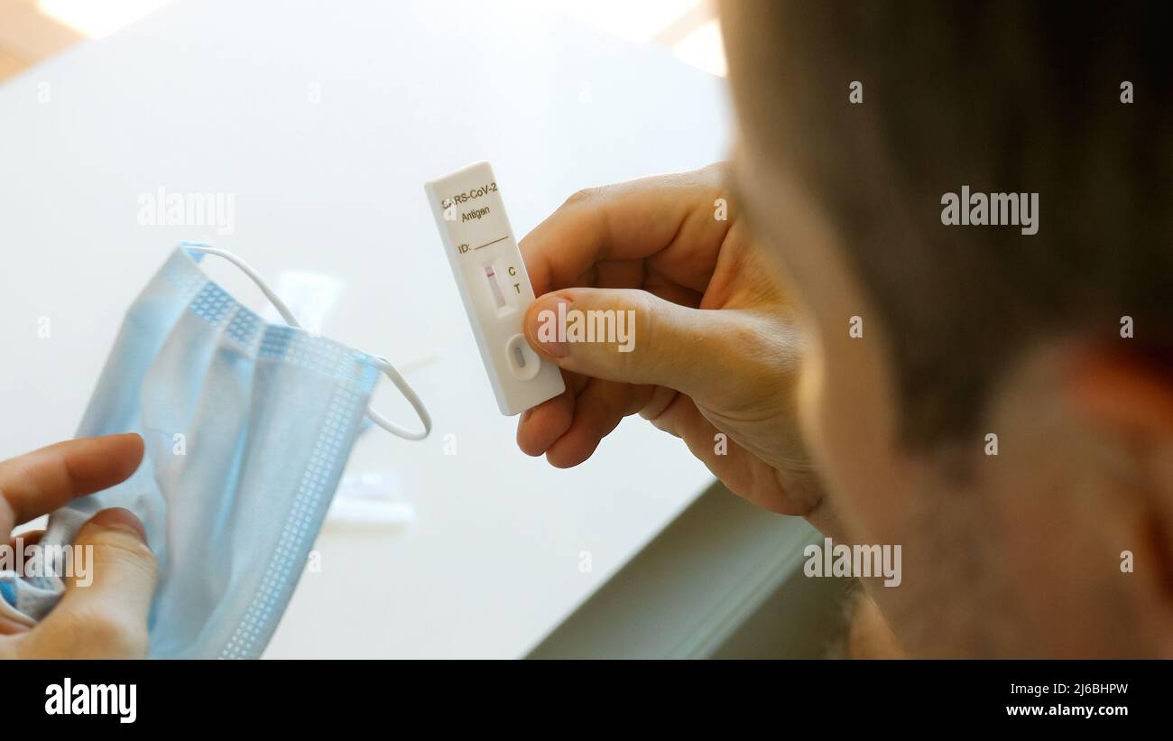 Man check result of covid-19 rapid antigen test kit at home, negative ...