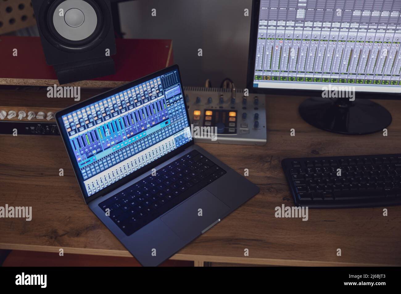 Top view of switched on laptop and monitor screen on table in sound ...