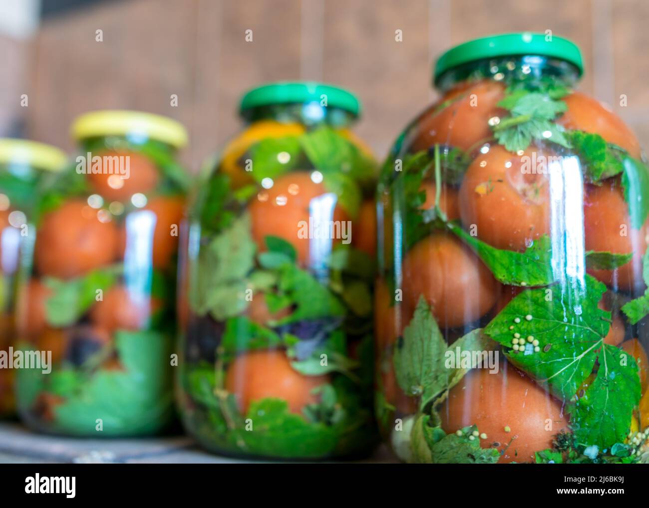 photography with red tomatoes and green spices in glass jars, canned ...