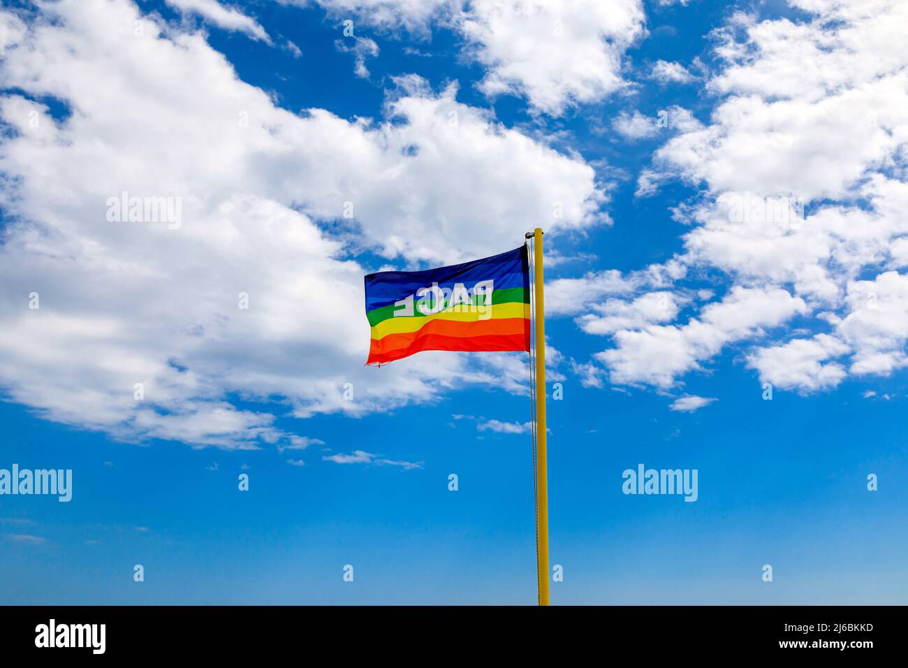 The flag in the colors of peace flutters against the backdrop of a ...