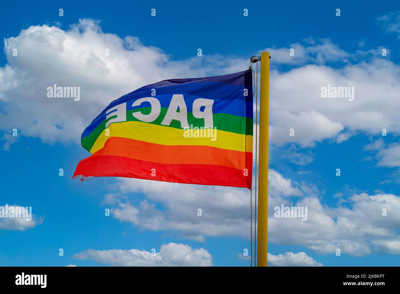 The flag in the colors of peace flutters against the backdrop of a ...