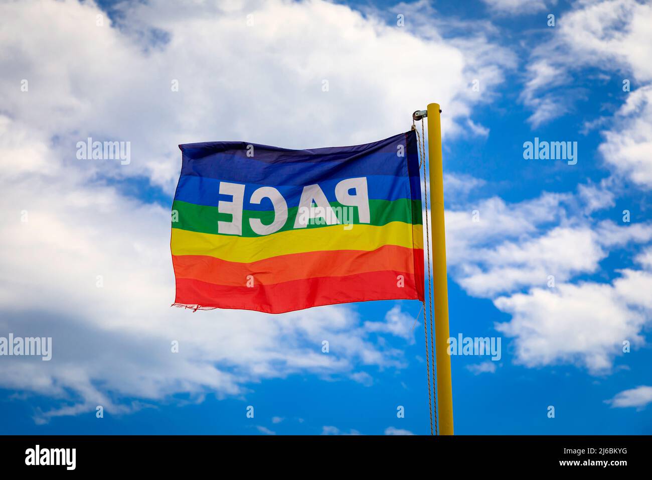 The flag in the colors of peace flutters against the backdrop of a ...