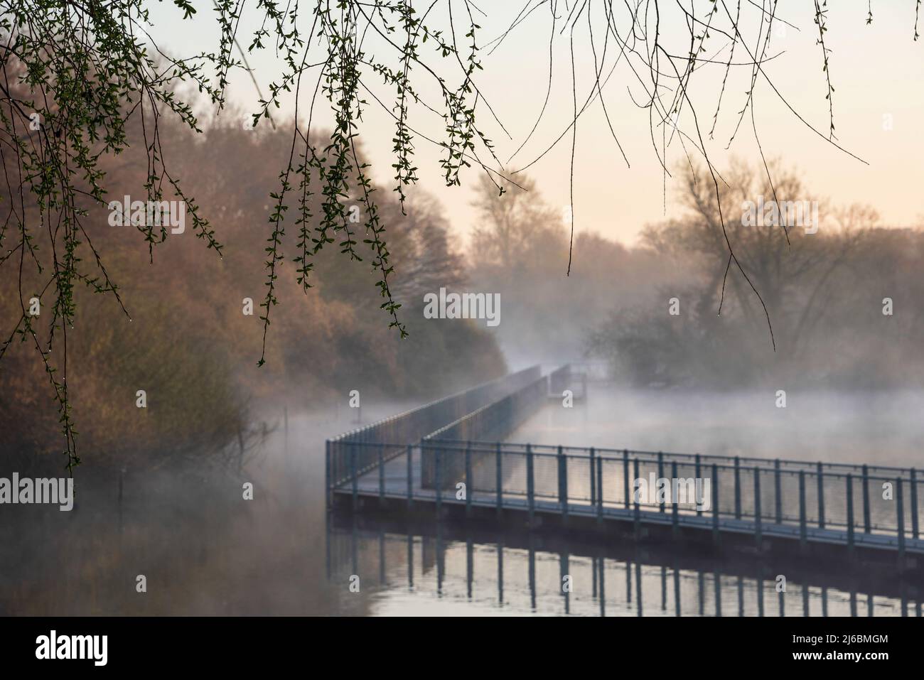Stunning landscape image of sunrise mist on urban lake with sun beams ...