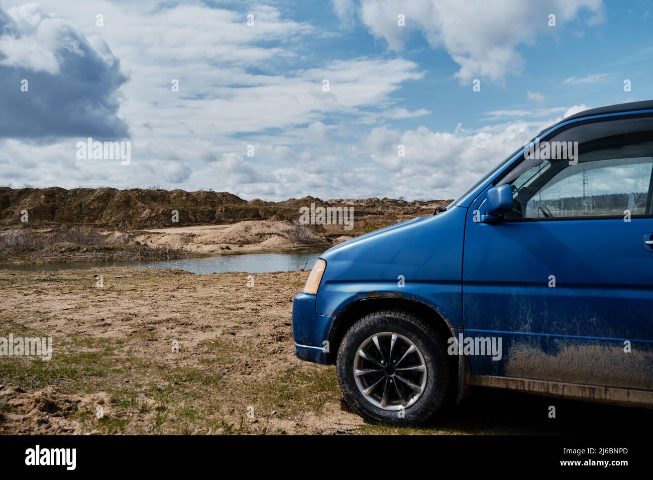 Sand quarry. A blue car is camping on clearing on background of sand ...