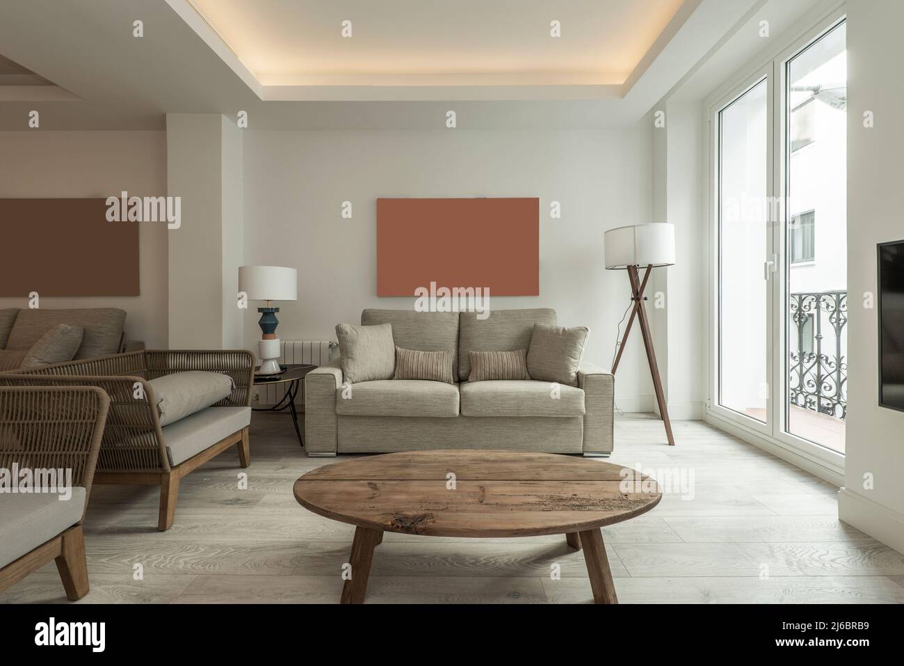 Living room with oval unvarnished wooden table on wooden floors ...