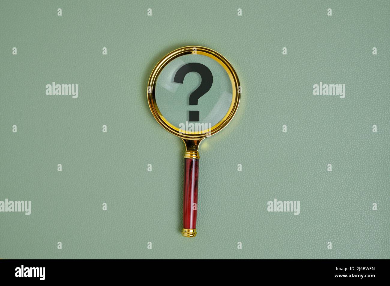 Question mark under magnifying glass, on green background Stock Photo ...