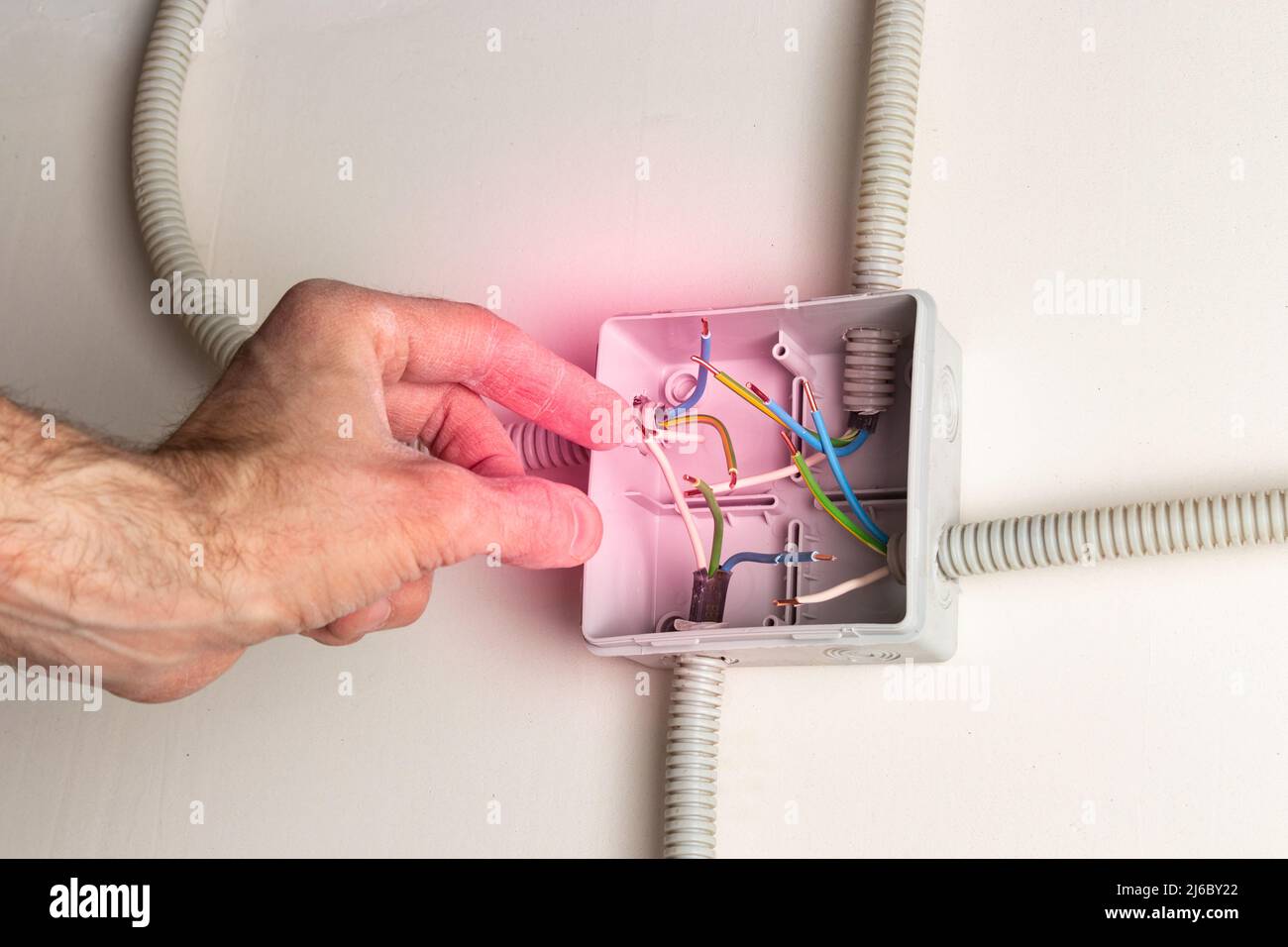 hand touches wires without insulation. Electrical safety concept Stock ...