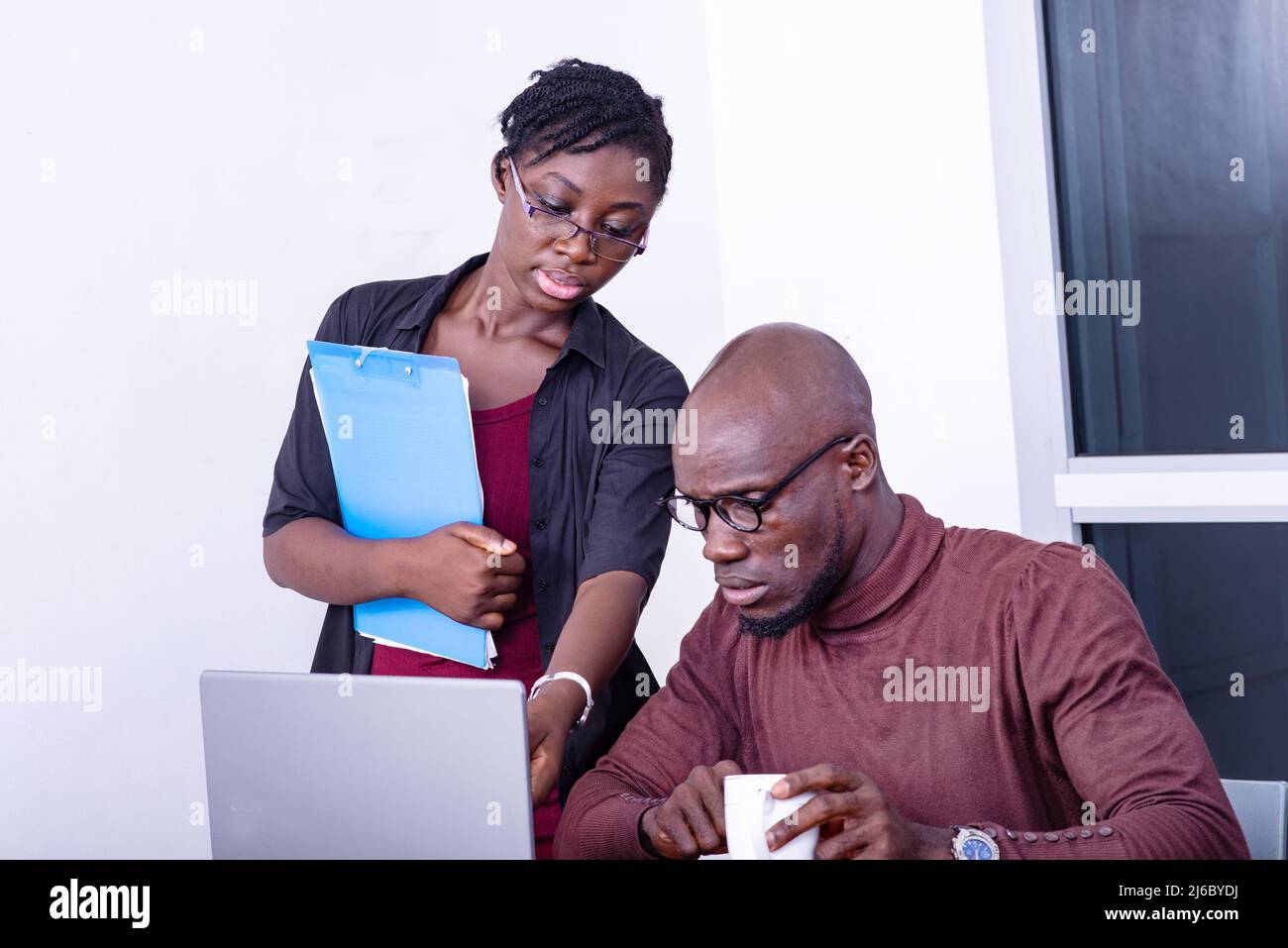 two serious business partners working together on laptop in the office ...