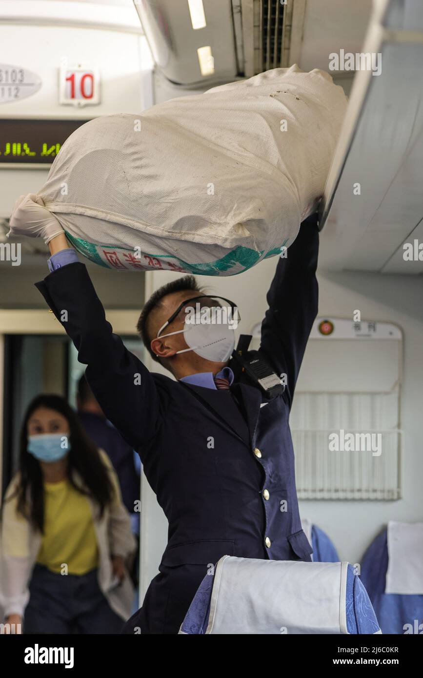 (220430) -- KASHGAR, April 30, 2022 (Xinhua) -- A train steward helps a ...