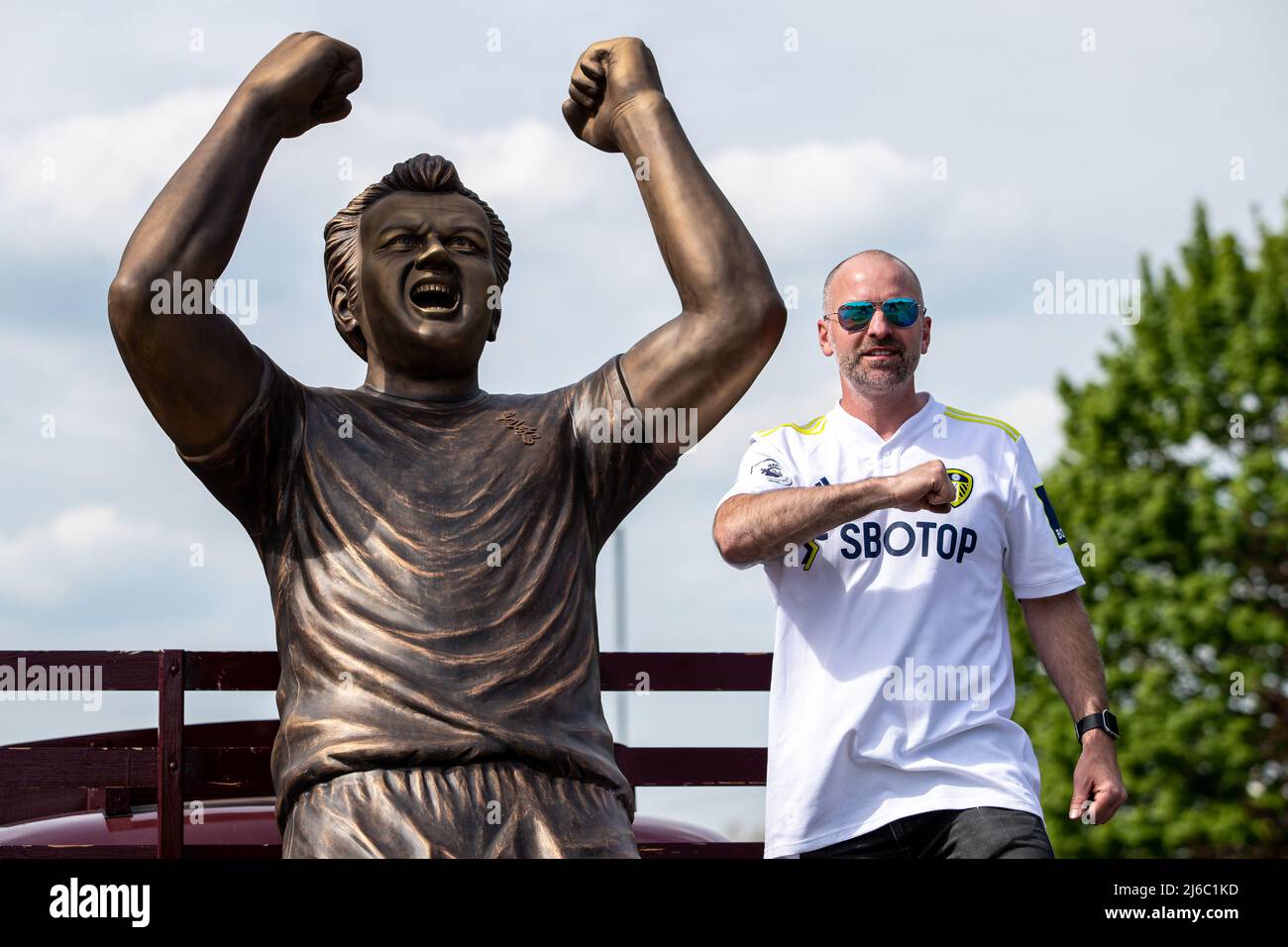 A Leeds United supporter stands beside a Billy Bremner statue which is ...