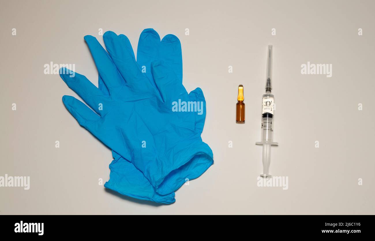 Blue medical gloves, syringe on a white background Stock Photo - Alamy