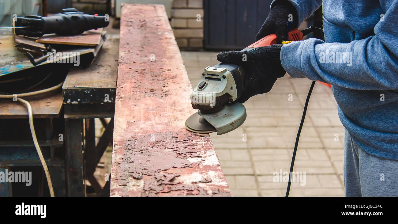 a man is grinding a board. Removing old paint from boards. Carpentry ...