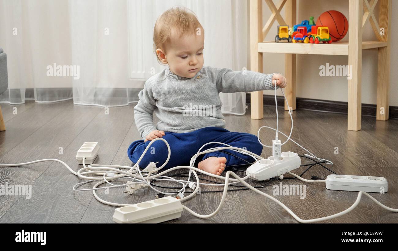 Little baby boy left alone playing with electric cables and wires Stock ...