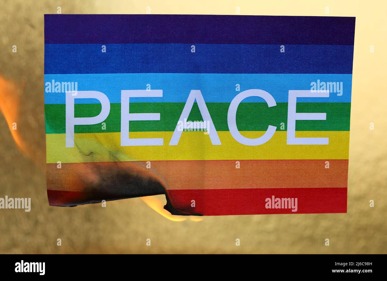 multicolored flag with the text PEACE while burning with the flame ...