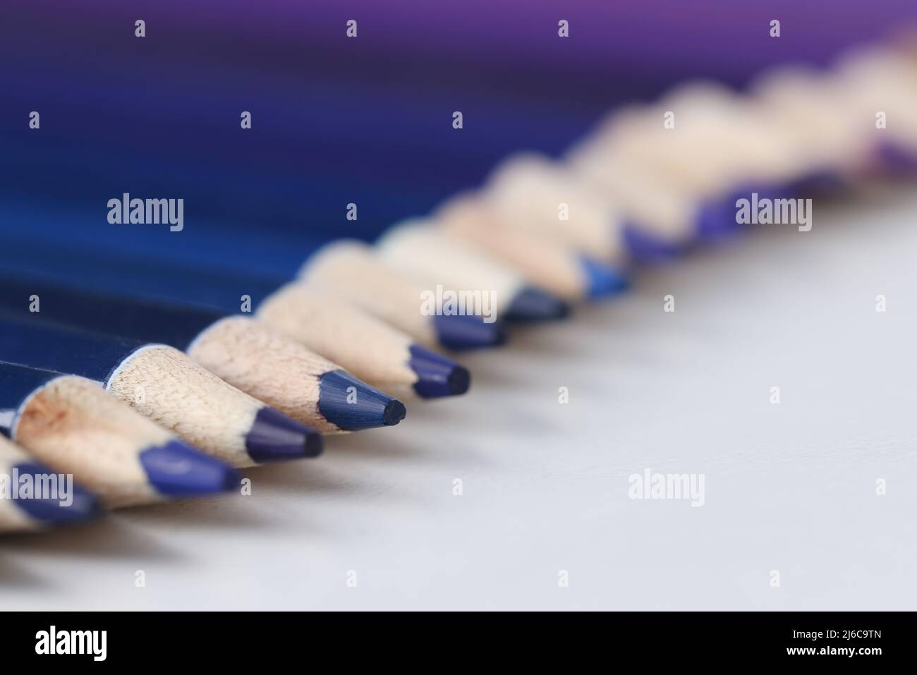 Close-up of set of blue identical pencils lie in raw. Several sharpened ...