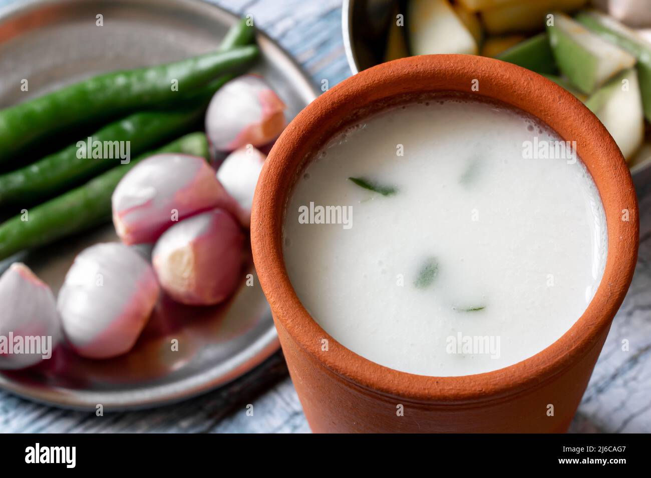 Fermented rice mixed with curd along with side dish of onion and green ...
