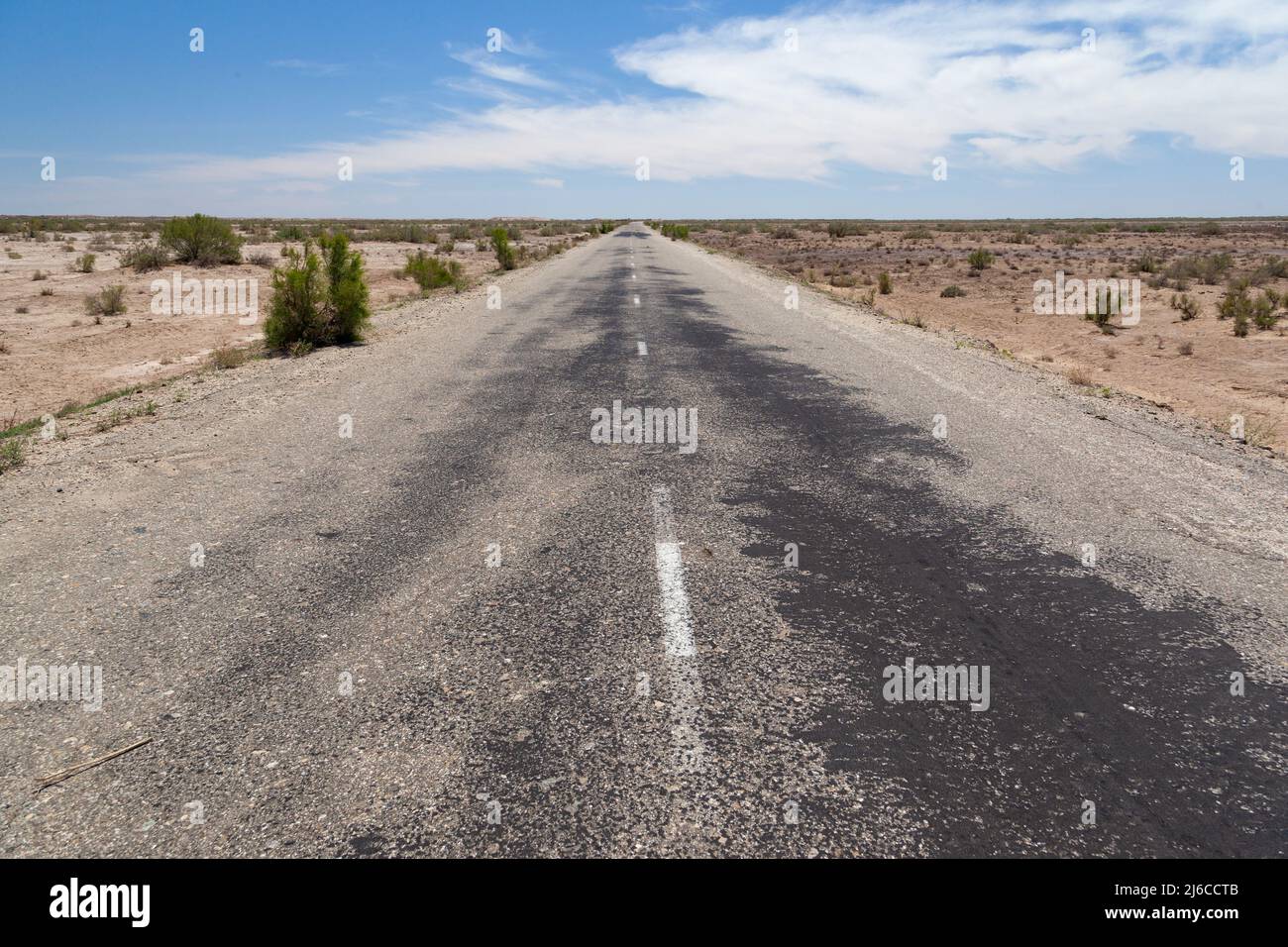 Long straight deserted road through desert in Uzbekistan showing road ...