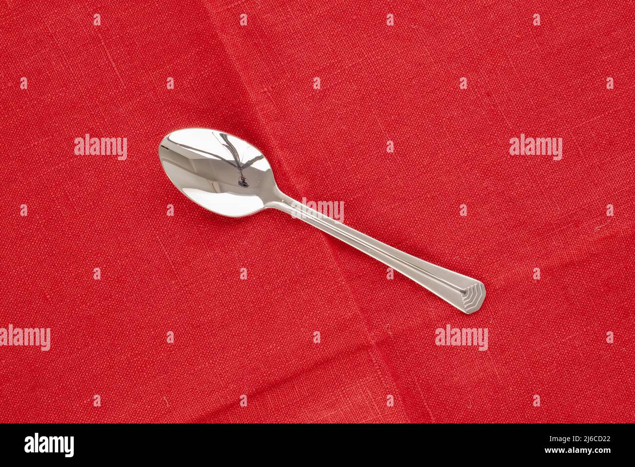 One metal spoon on a red linen napkin, macro, top view Stock Photo - Alamy
