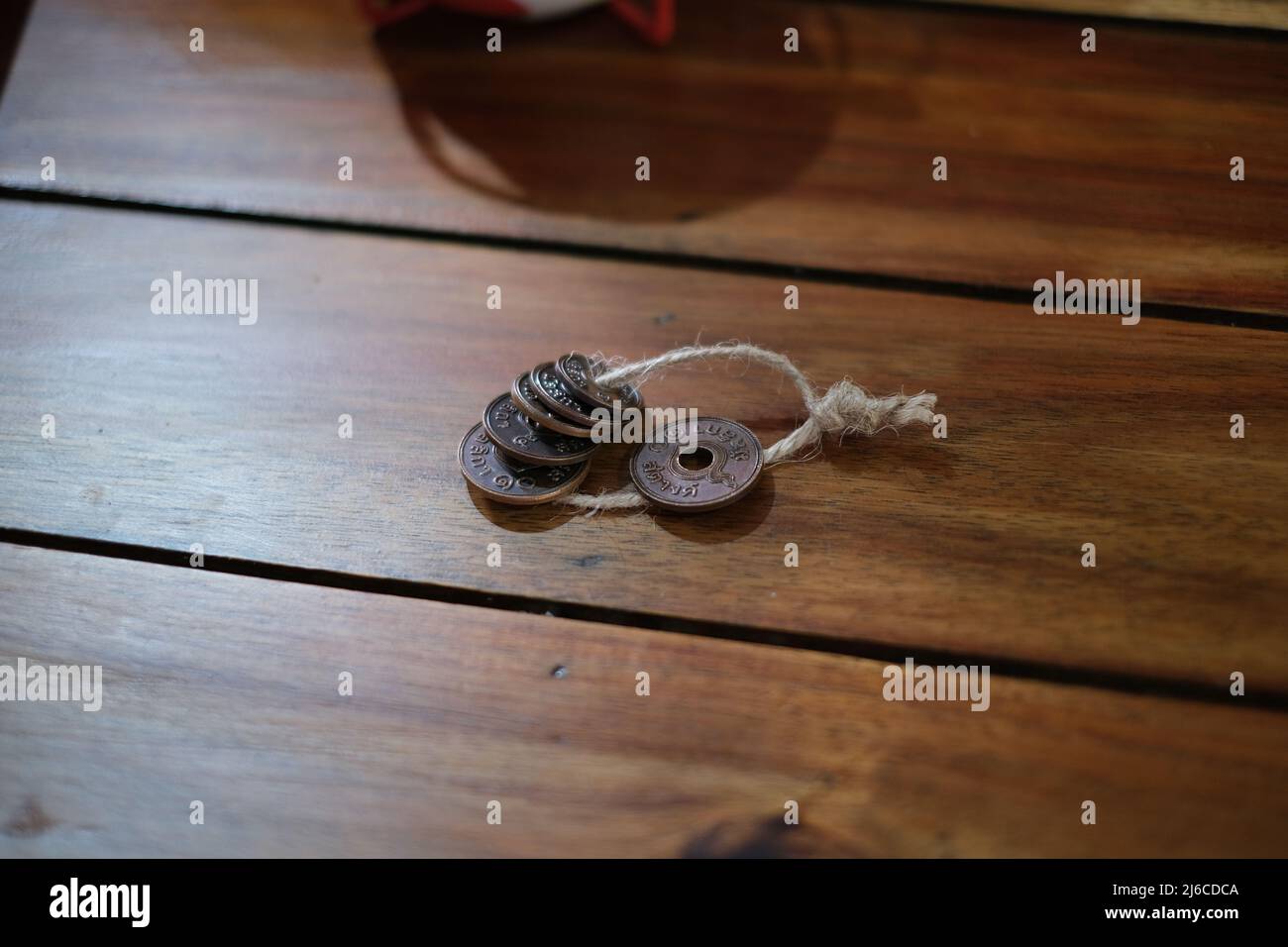 A bunch of ancient Thai coins, strung together for convenience Stock ...