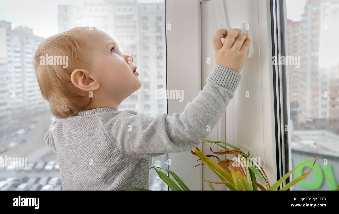 Little baby pressing knob and pulling window handle trying to open ...
