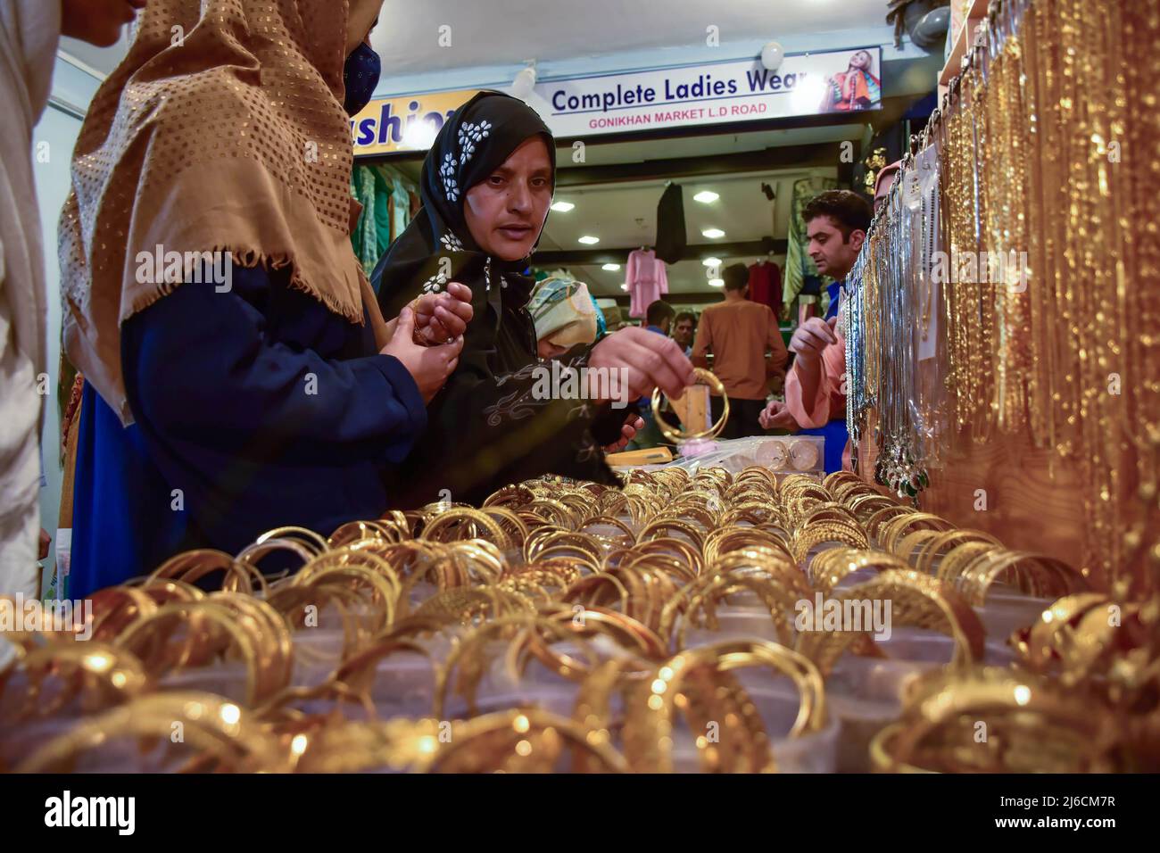 A Kashmiri woman shops at a jewelry store ahead of Muslim festival Eid al-Fitr at a local market ...