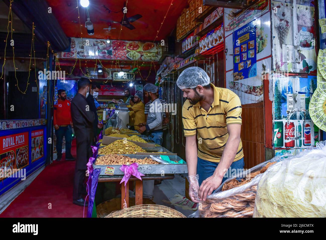 Kashmiri residents shop at a bakery store ahead of the Muslim festival ...