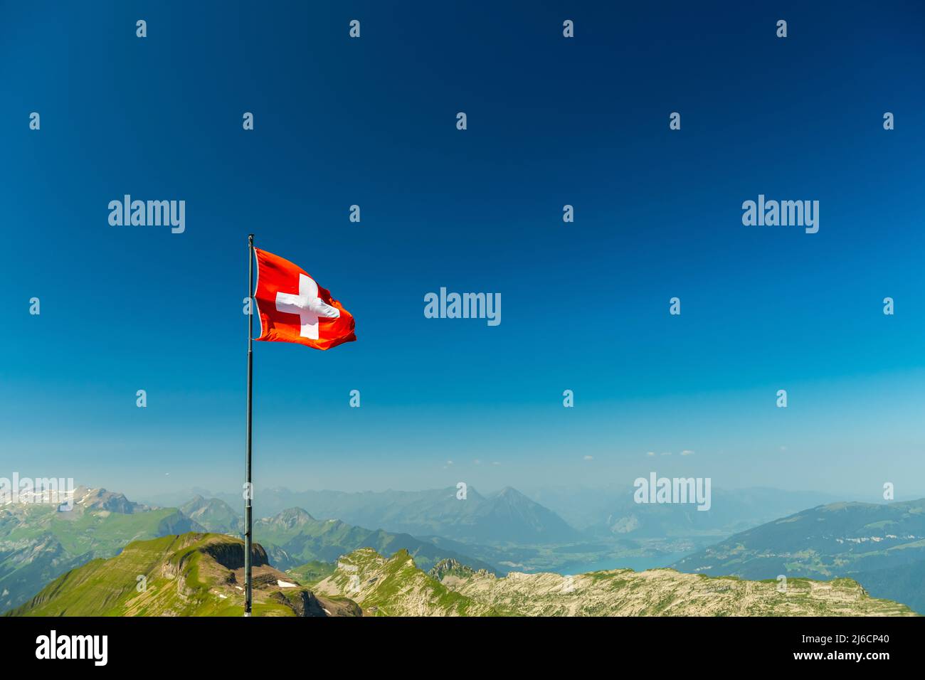 The Swiss flag waves in the wind on a mountain Stock Photo - Alamy
