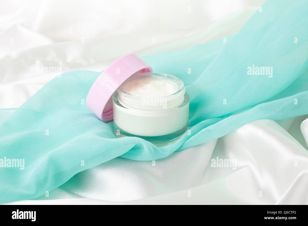 Hand cream jar on satin folds fabric, smooth background mockup Stock ...