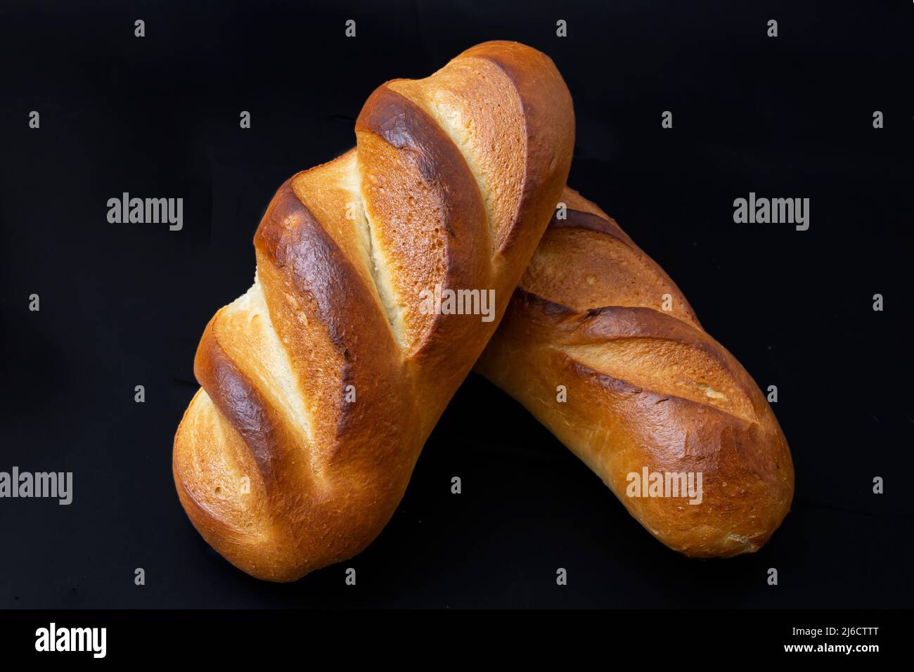 two bread loaves, isolated on black background Stock Photo - Alamy