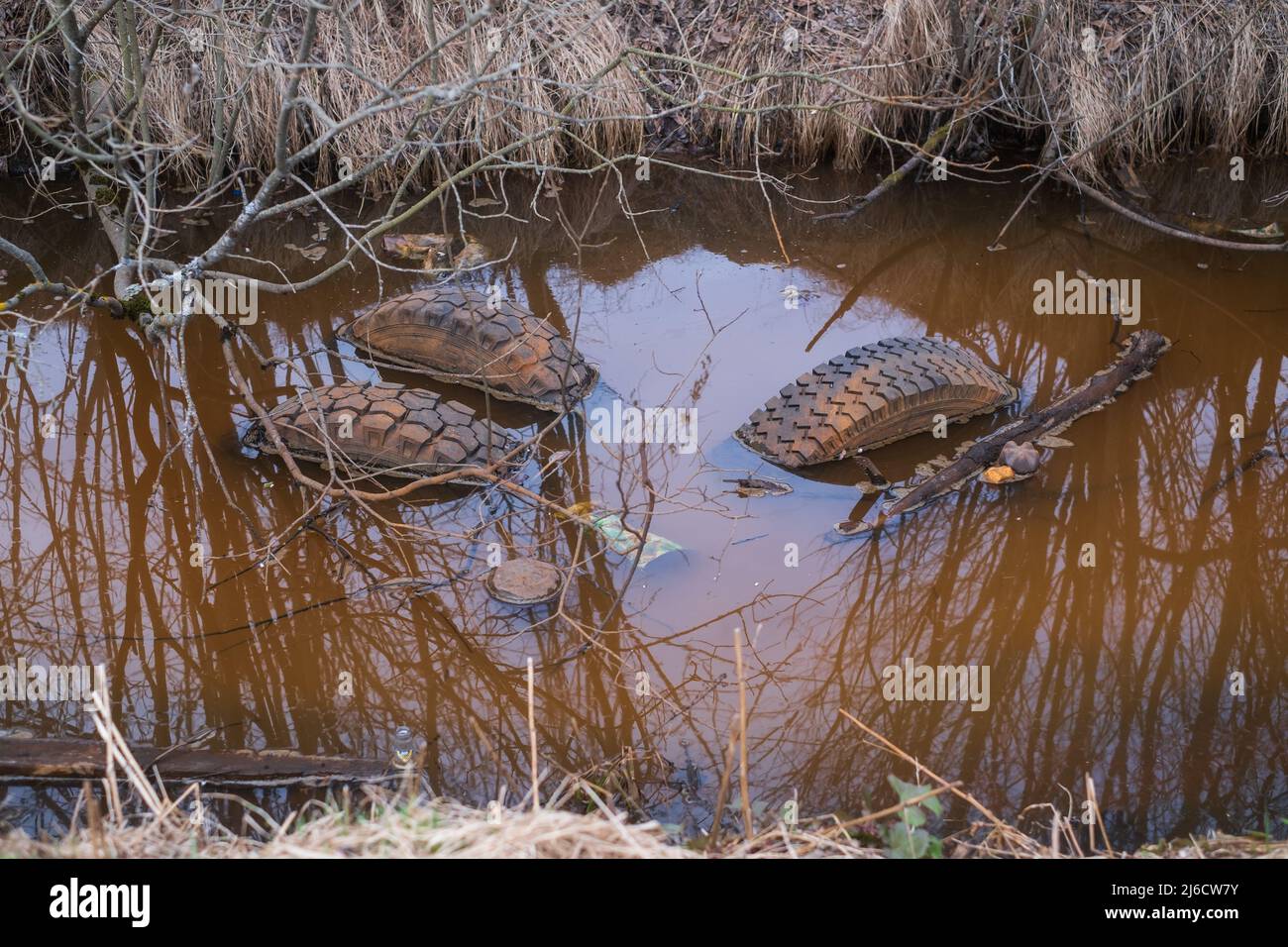 Garbage junk items left in nature in ditch with water. Environmental ...