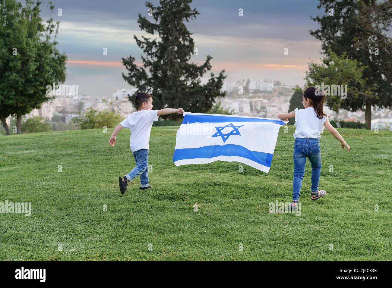 Young children running with Israeli flag. Rear view little girl and boy ...