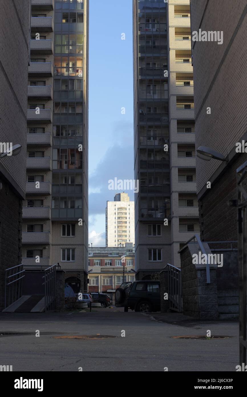 Narrow way between the high apartment buildings Stock Photo - Alamy