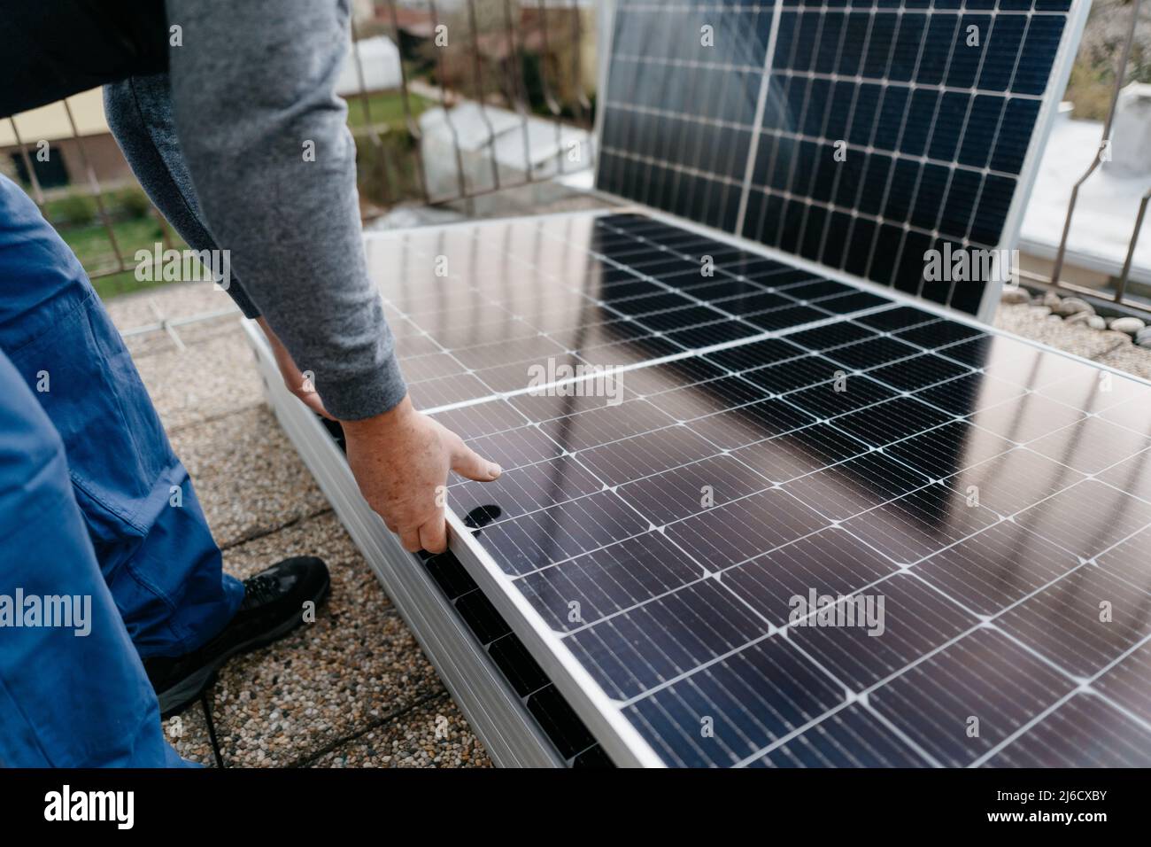 close up. man holds the solar panel and sets the correct position ...