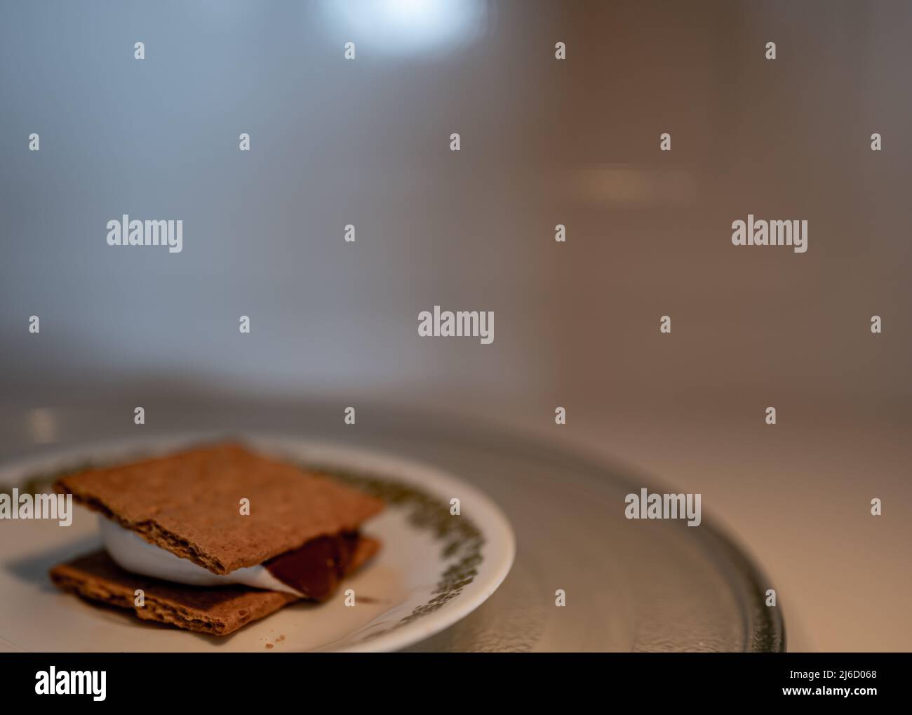 Making a smore with a marshmallow, cracker, and chocolate using a ...