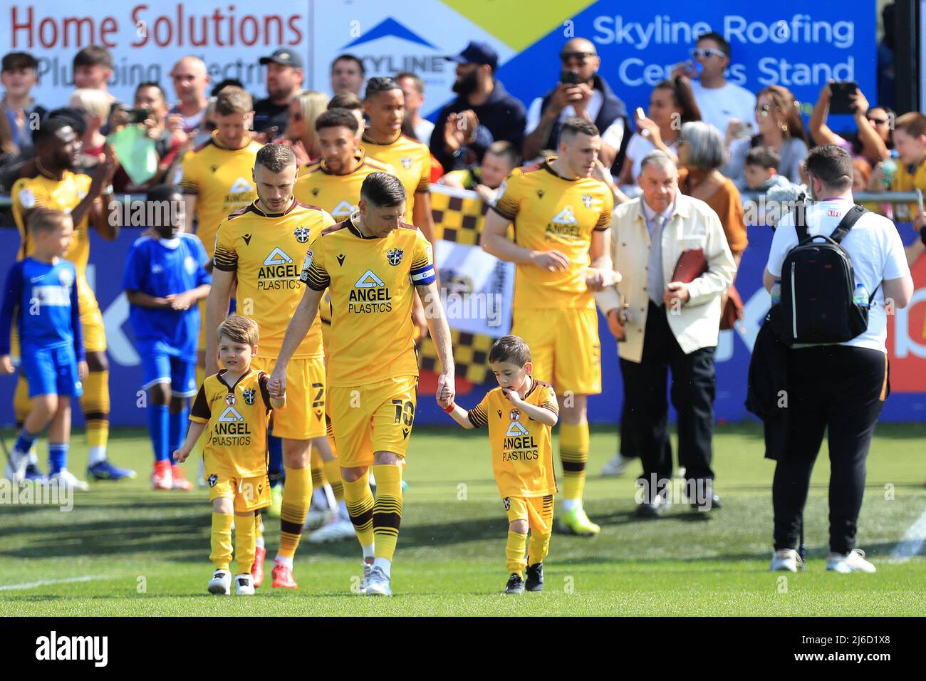 Harry Beautyman #10 of Sutton United leads out the match day mascots ...