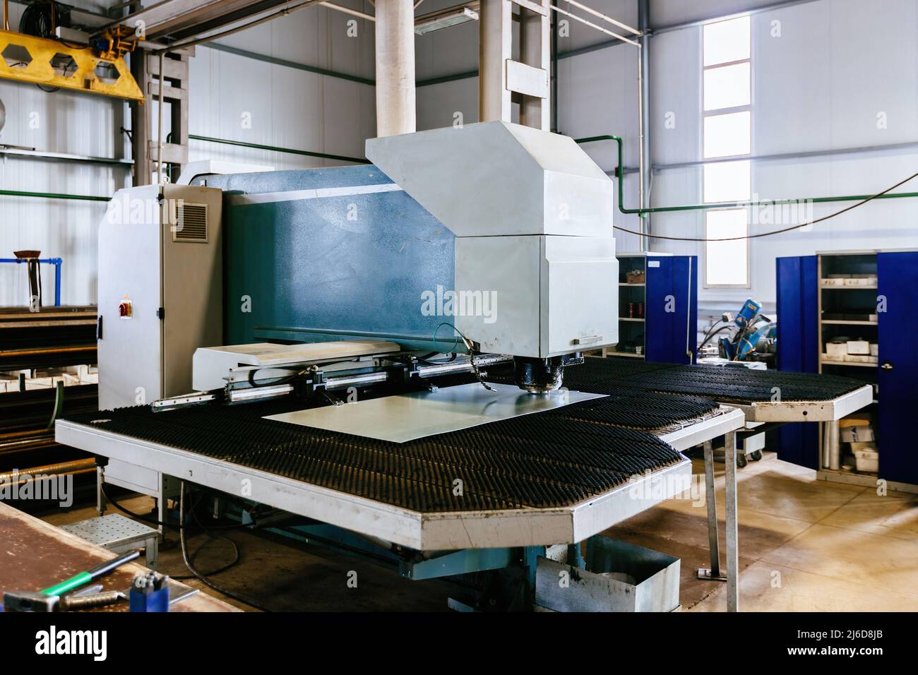 CNC punching and nibbling machine and perforated steel sheet, close up ...