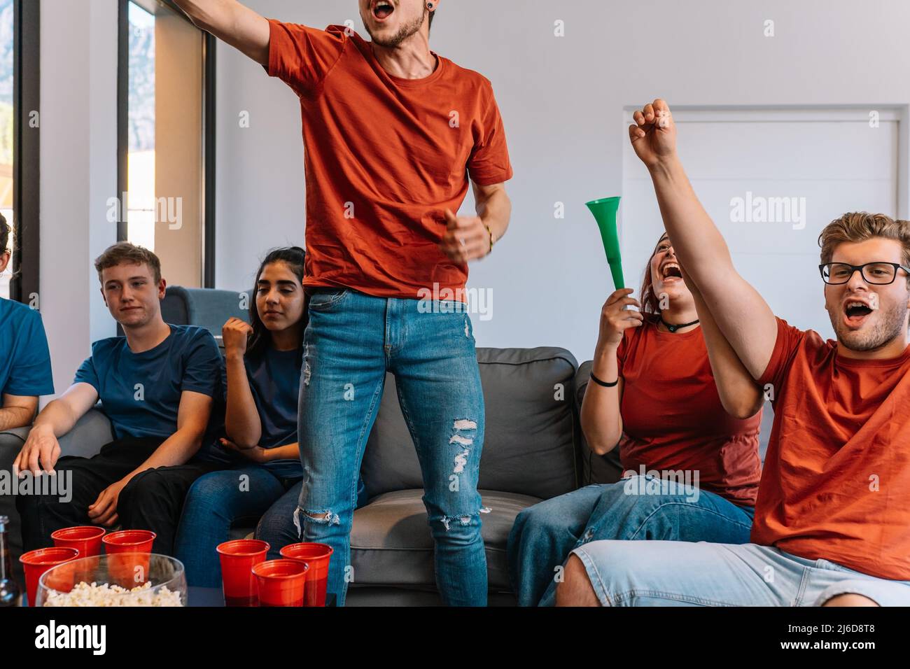 friends jumping for joy after their team's victory, watching football ...