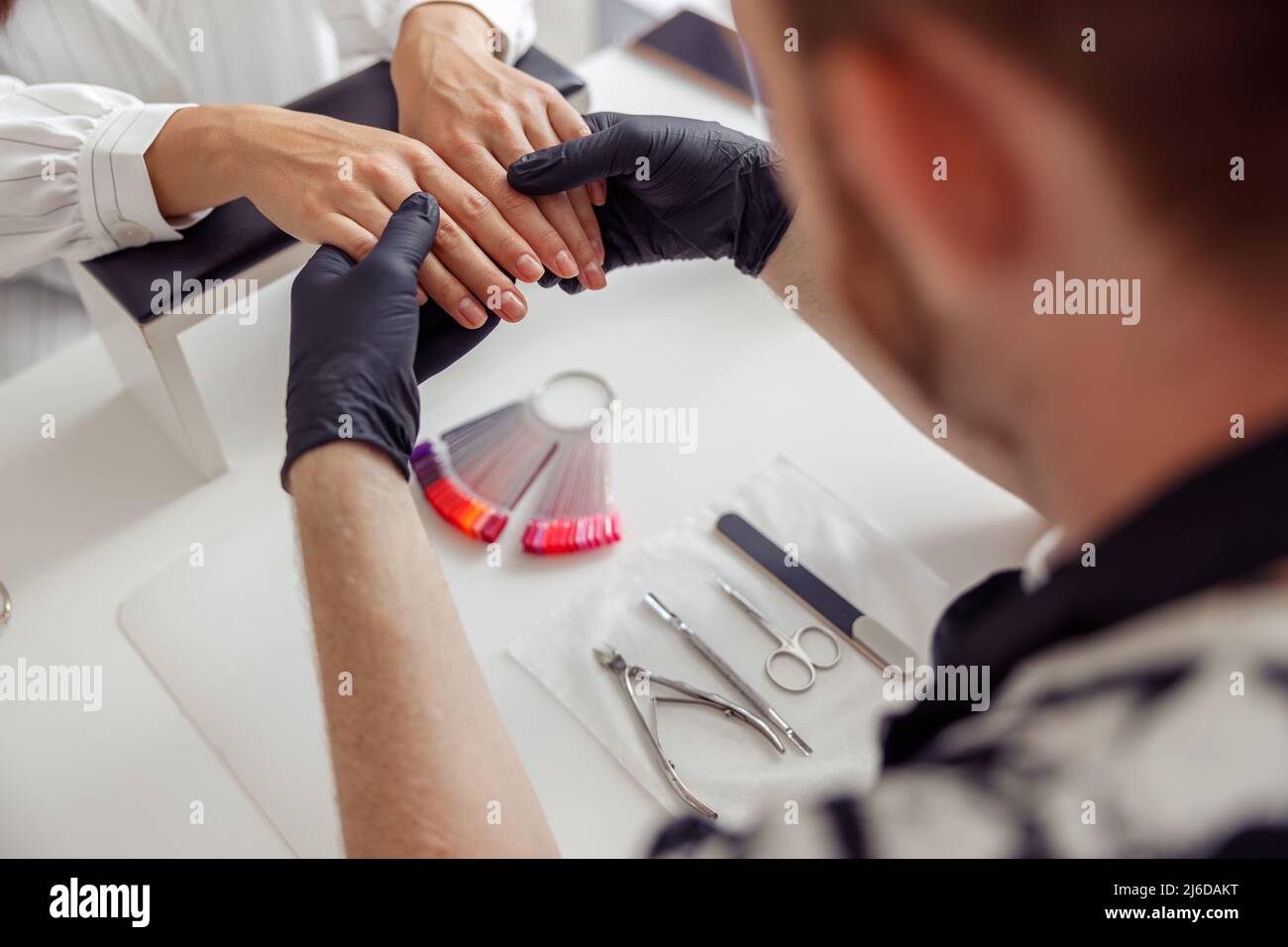 Nail master working on client nails at beauty center Stock Photo - Alamy