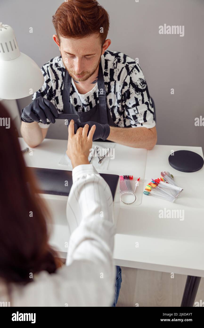Nail master working on client nails at beauty center Stock Photo - Alamy