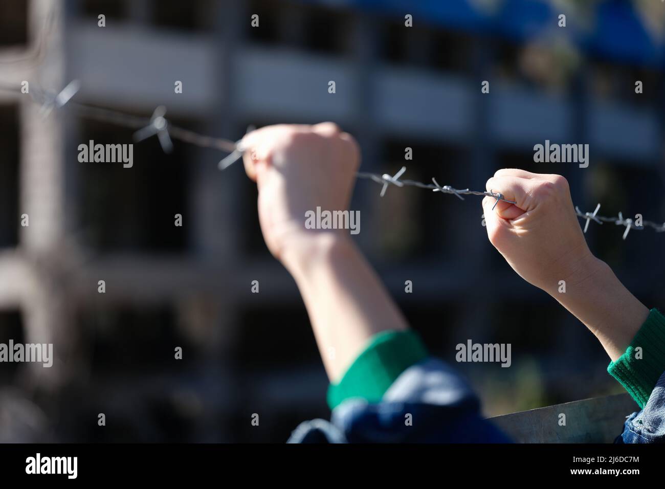Hand behind barbed wire in prison or slavery closeup Stock Photo - Alamy